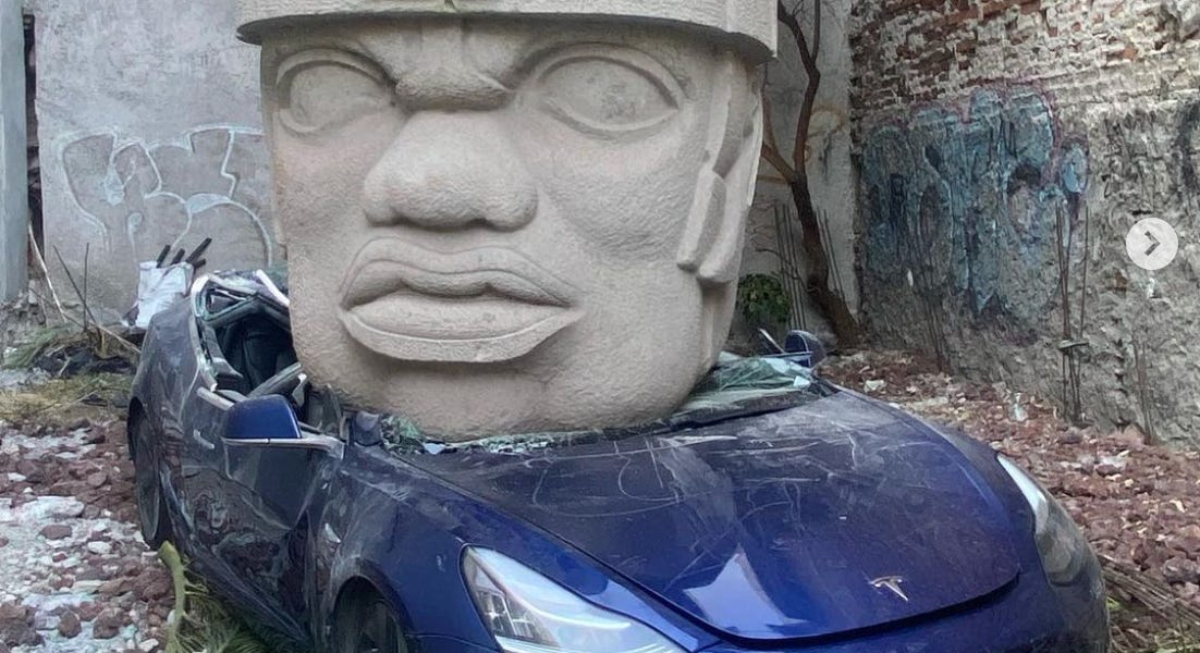 Tesla crushed by giant head sculpture - Zivvy News